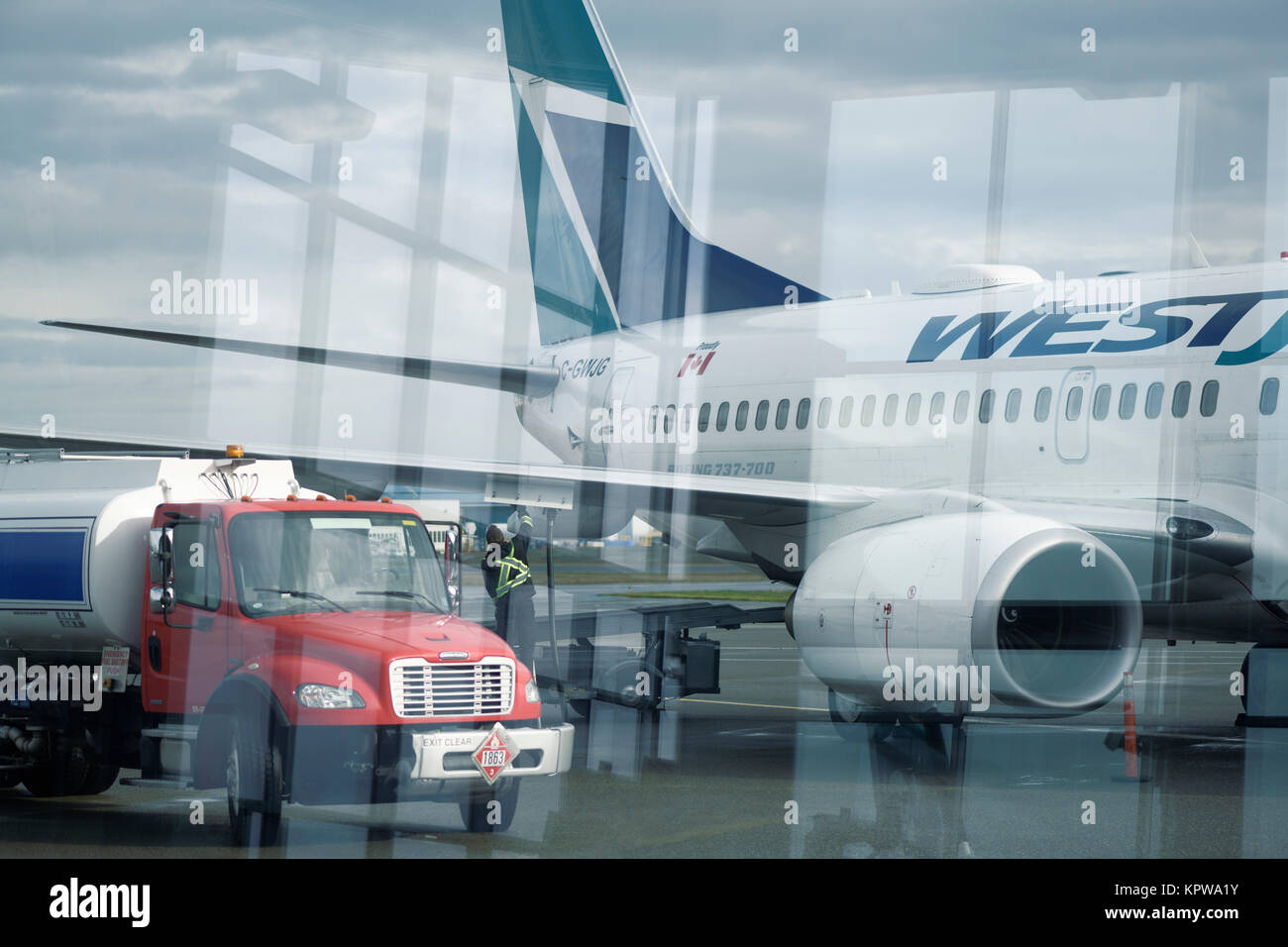 Artistic photo of fuel tanker track refueling WestJet airplane before a ...