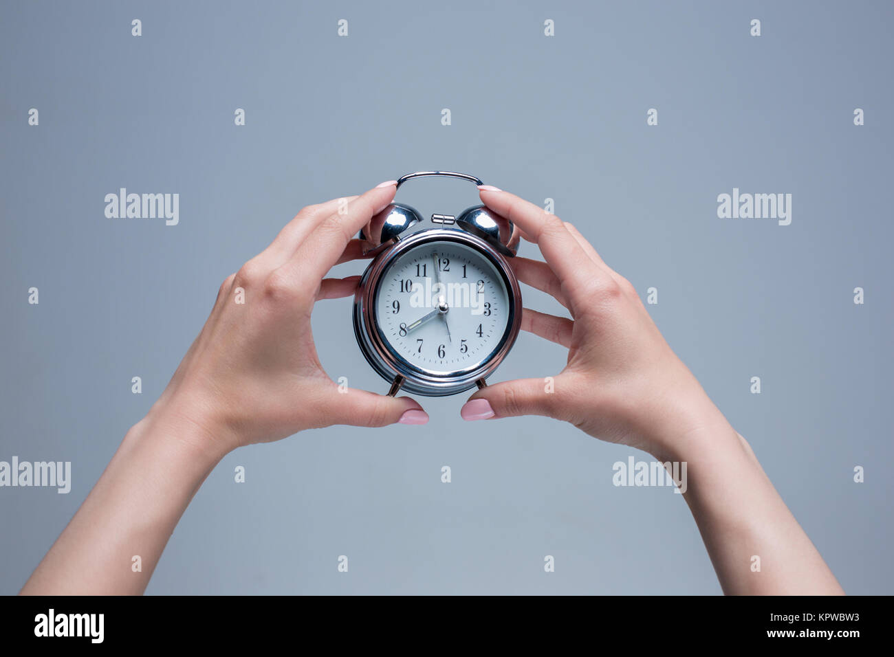 The female hands and old style alarm clock Stock Photo - Alamy