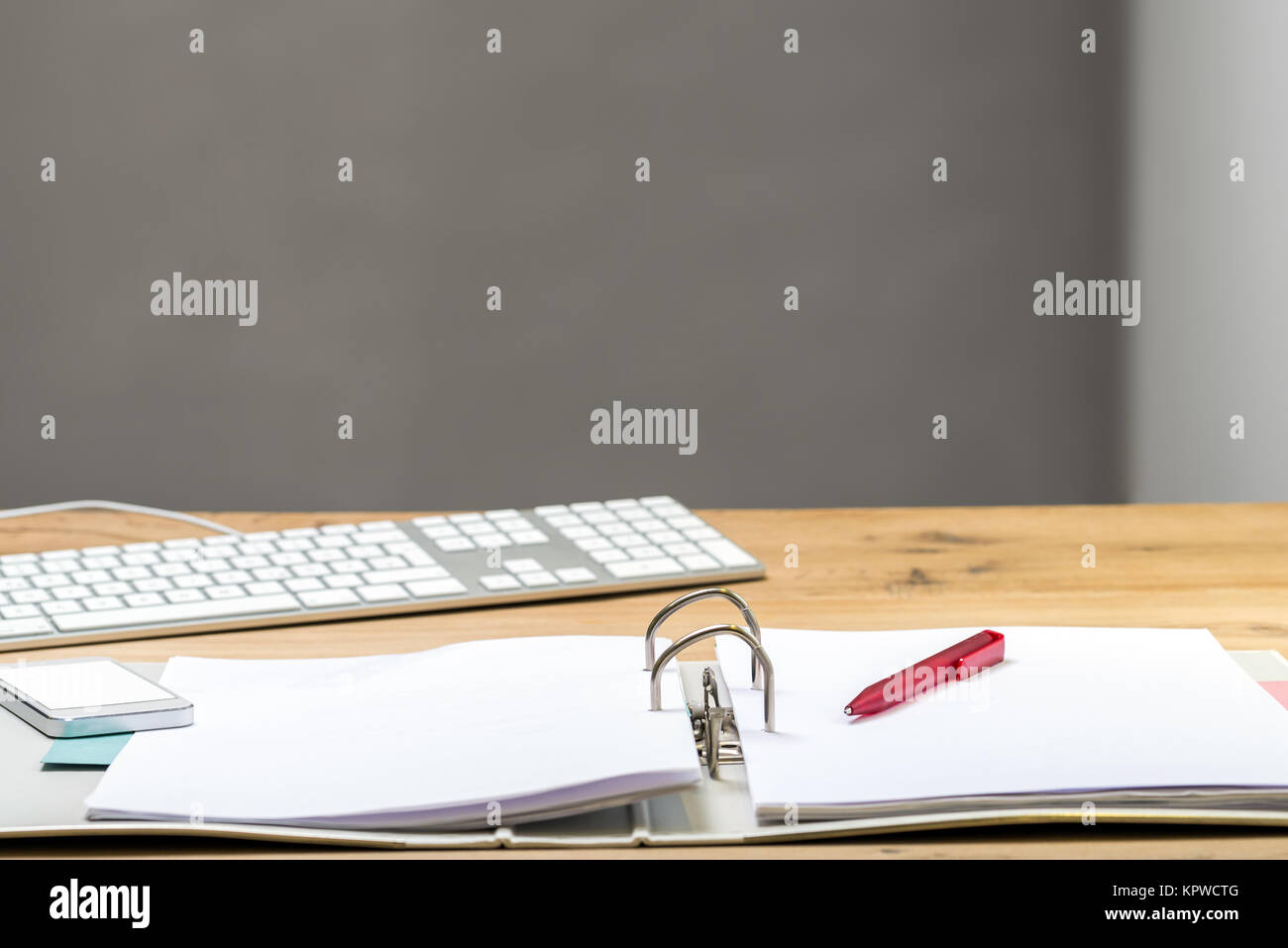 Open folder with keyboard and phone lying on wooden desk Stock Photo ...