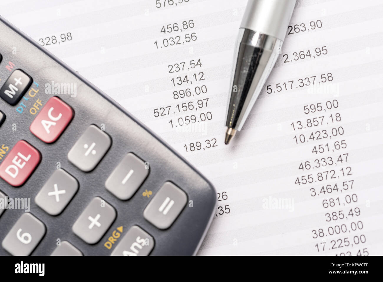 Calculator lying on top of sheet of paper with charts as closeup Stock ...