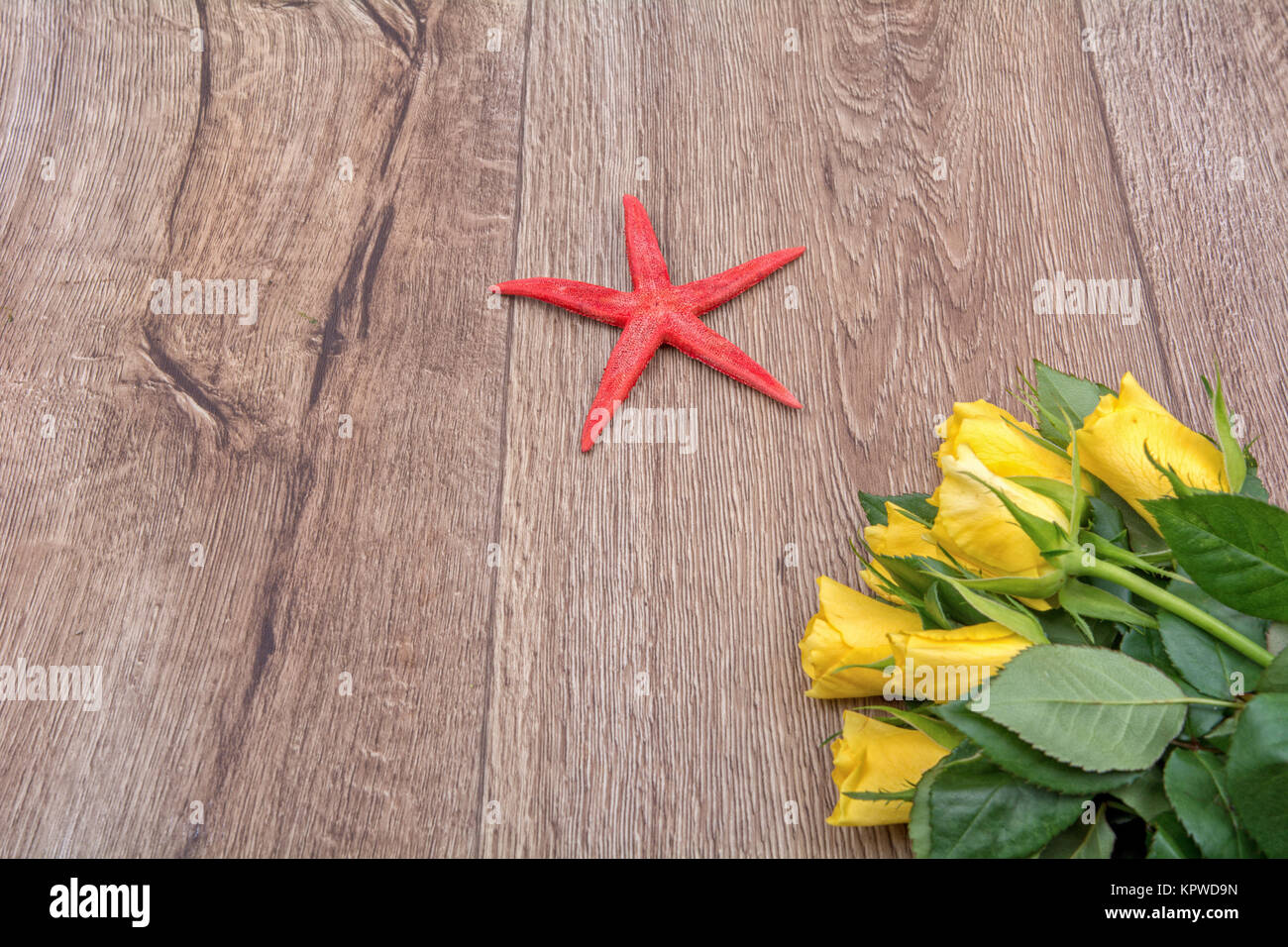 Red starfish and roses on a wooden background Stock Photo - Alamy