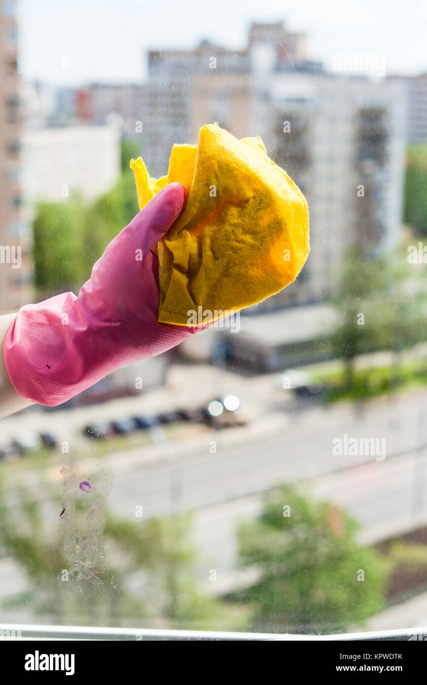 washer cleans window glass by rag in urban house Stock Photo - Alamy