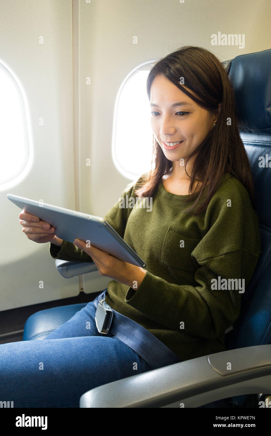 Woman using tablet on board the aircraft Stock Photo - Alamy