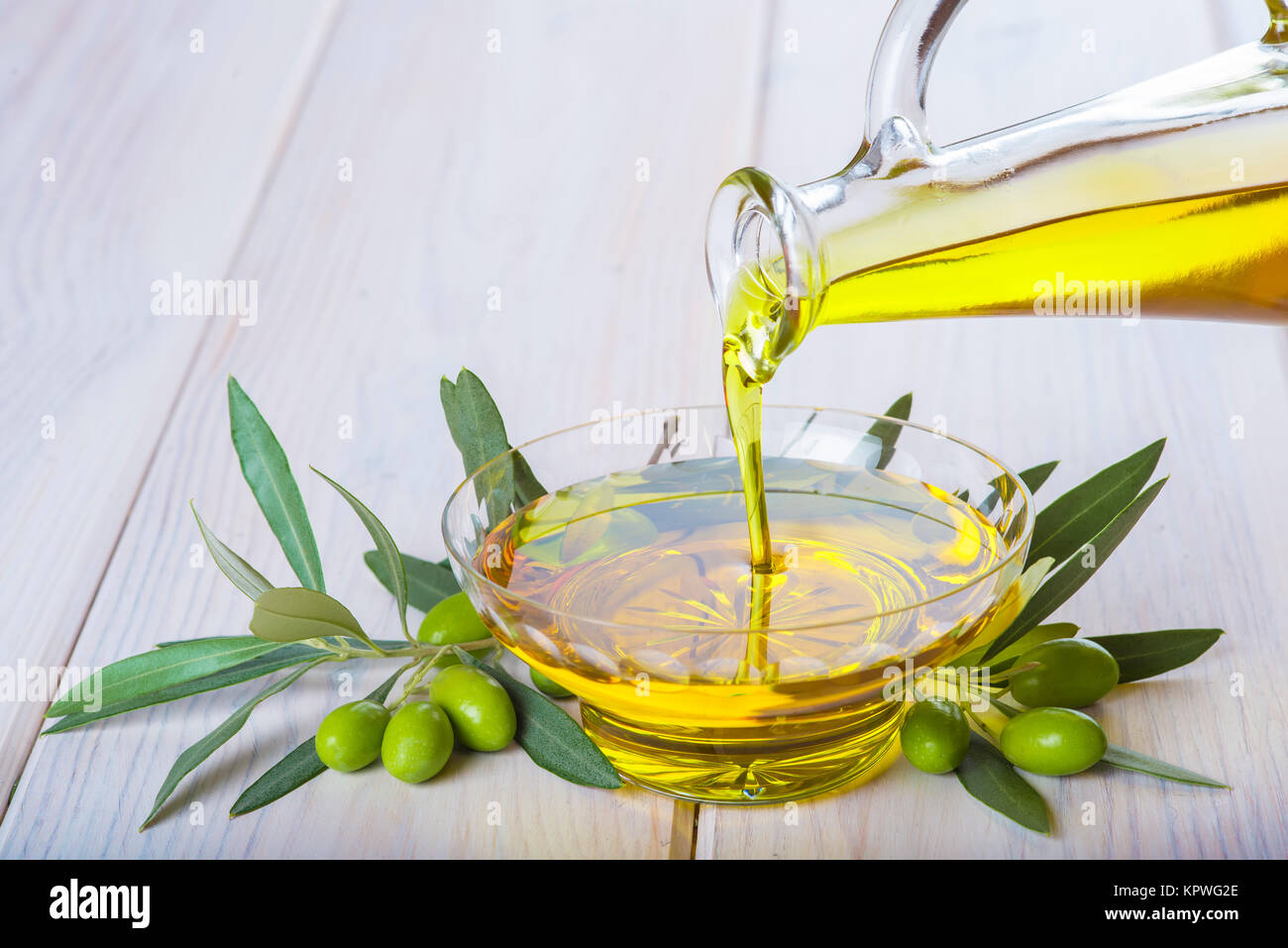Bottle pouring virgin extra olive oil in a bowl Stock Photo - Alamy