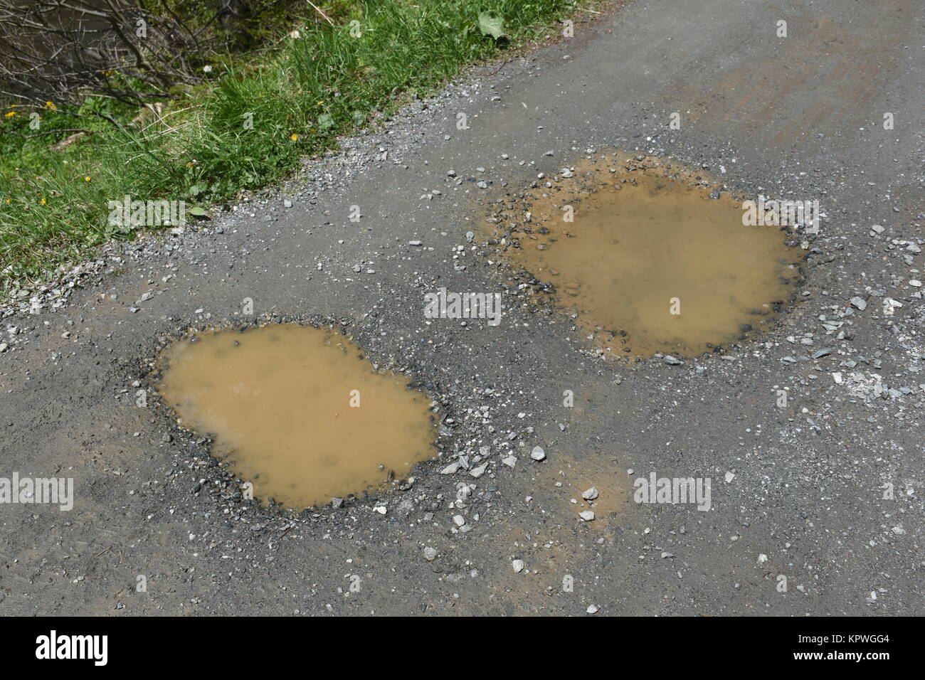 puddle of water on gravel road Stock Photo - Alamy