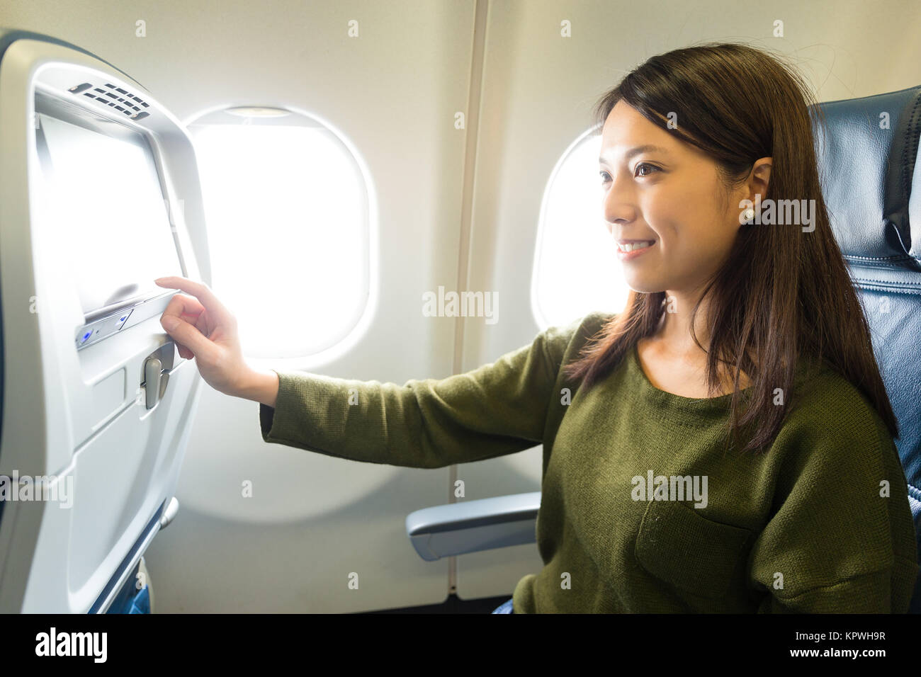Woman use of the entertainment on airplane Stock Photo - Alamy