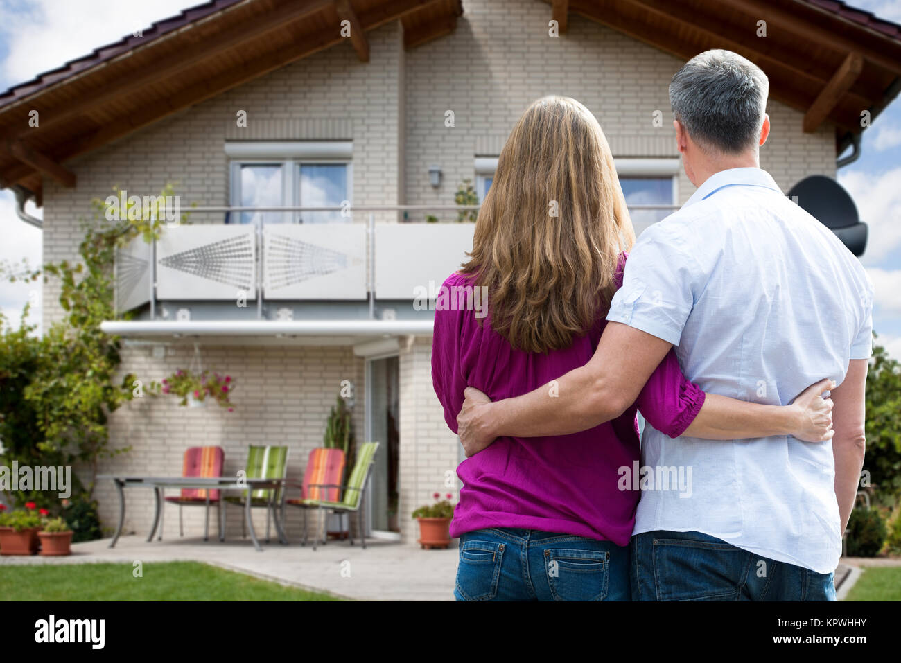 Couple Standing In Front Of Their House Stock Photo - Alamy