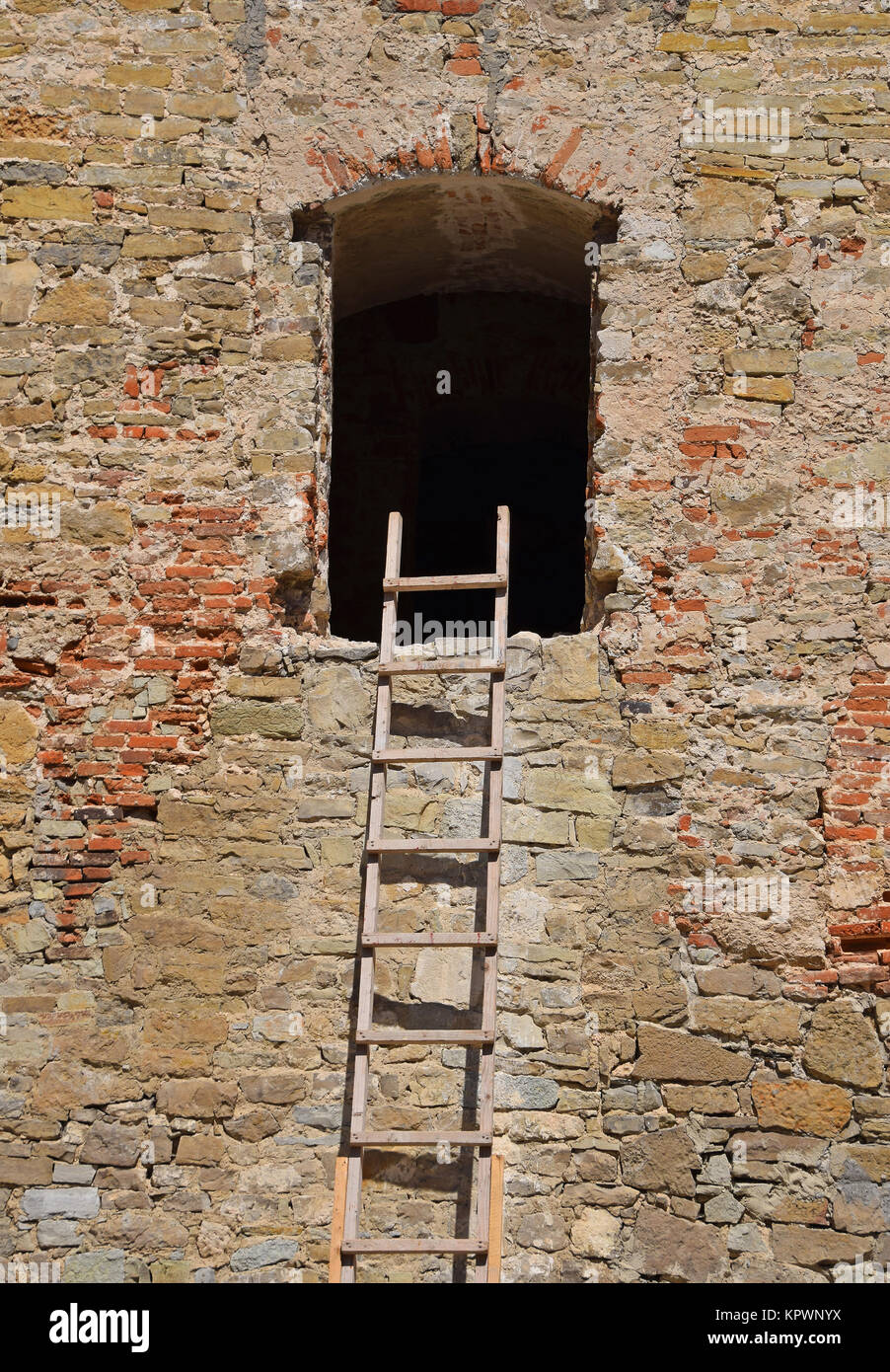 Wooden ladder near window of old stone wall Stock Photo - Alamy
