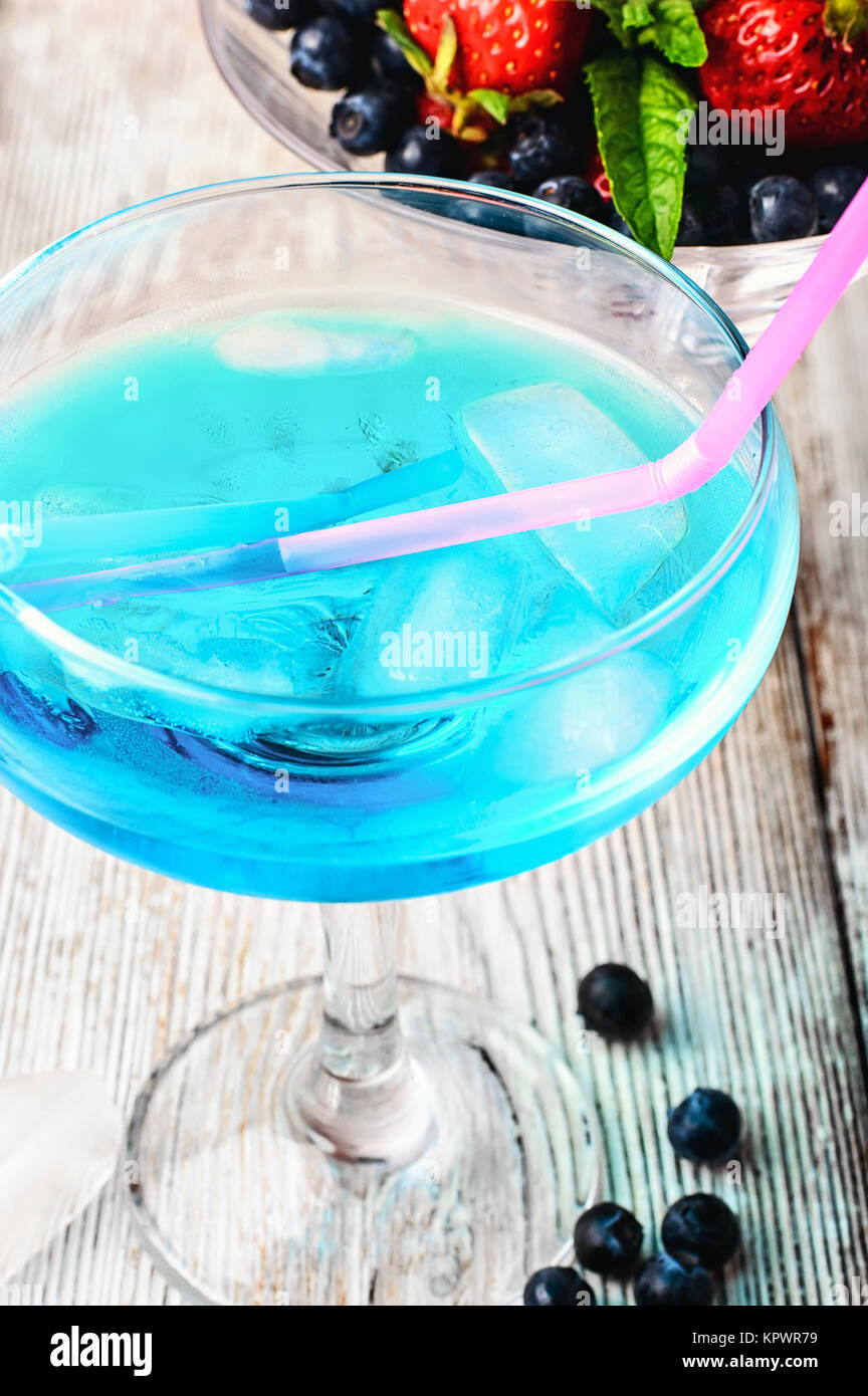 Alcohol in stylish blue color glass glass on long stalk Stock Photo - Alamy