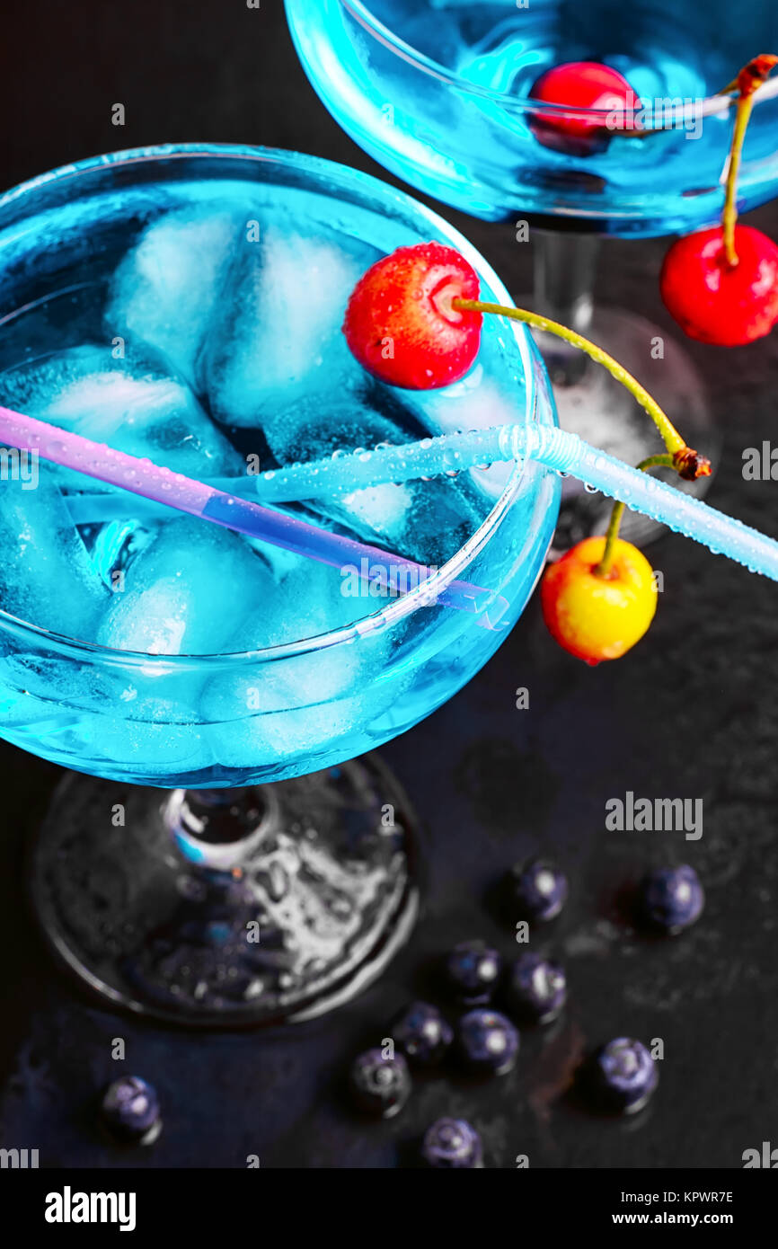 glass of blue alcohol cocktail in glass with cherry Stock Photo - Alamy