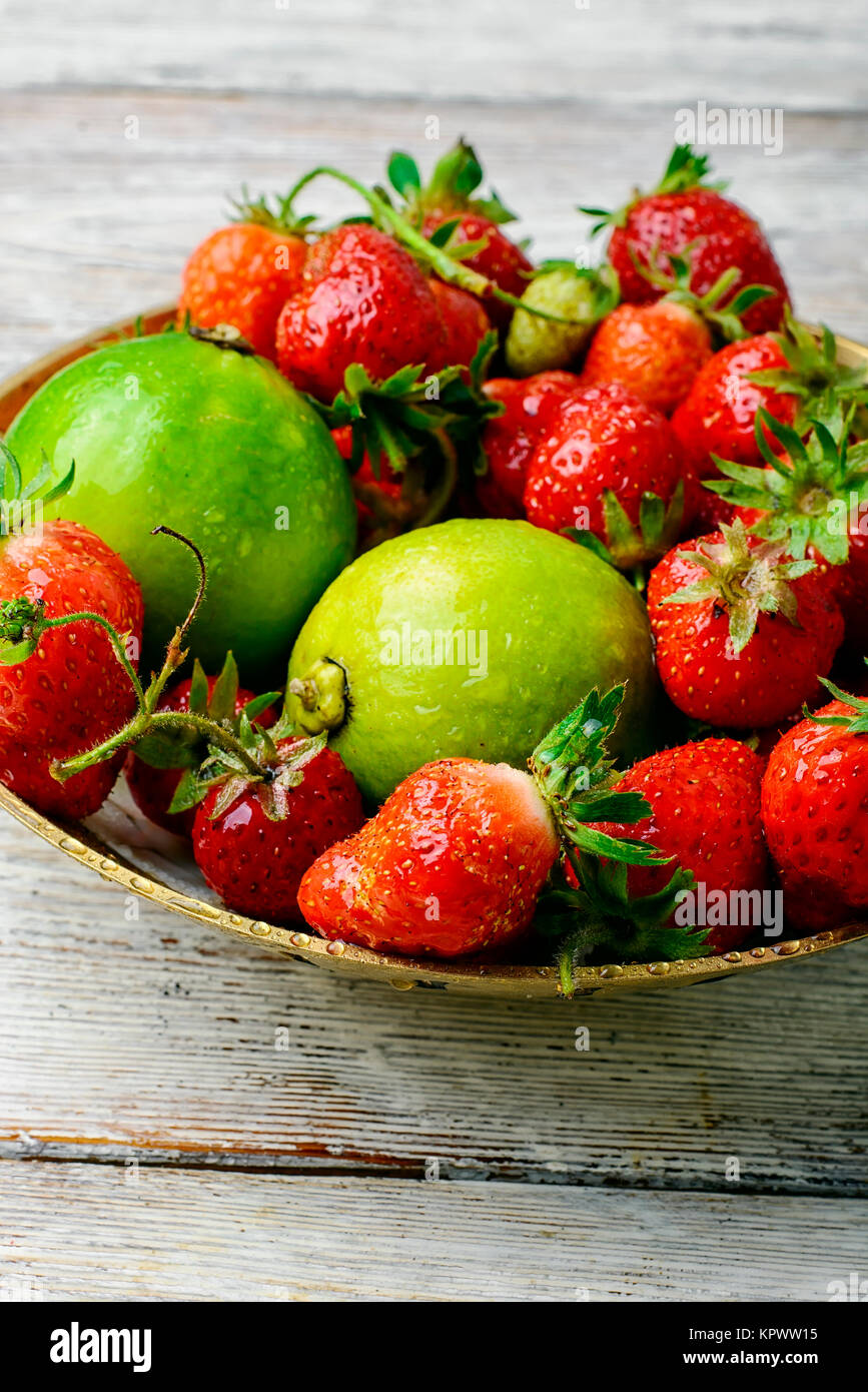 Harvest rustic strawberry and lime fruit on light background Stock ...
