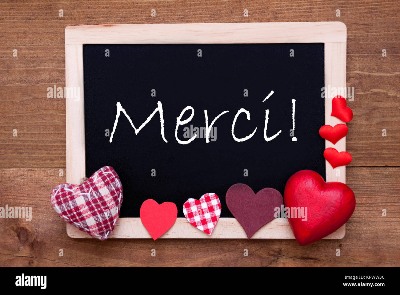 Blackboard With French Text Merci Means Thank You. Red Textile Hearts ...