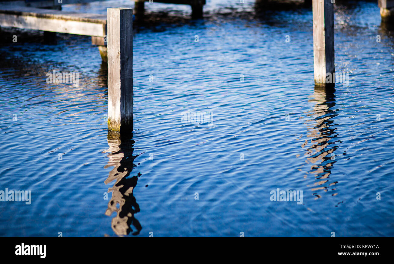 Wooden posts in water Stock Photo - Alamy