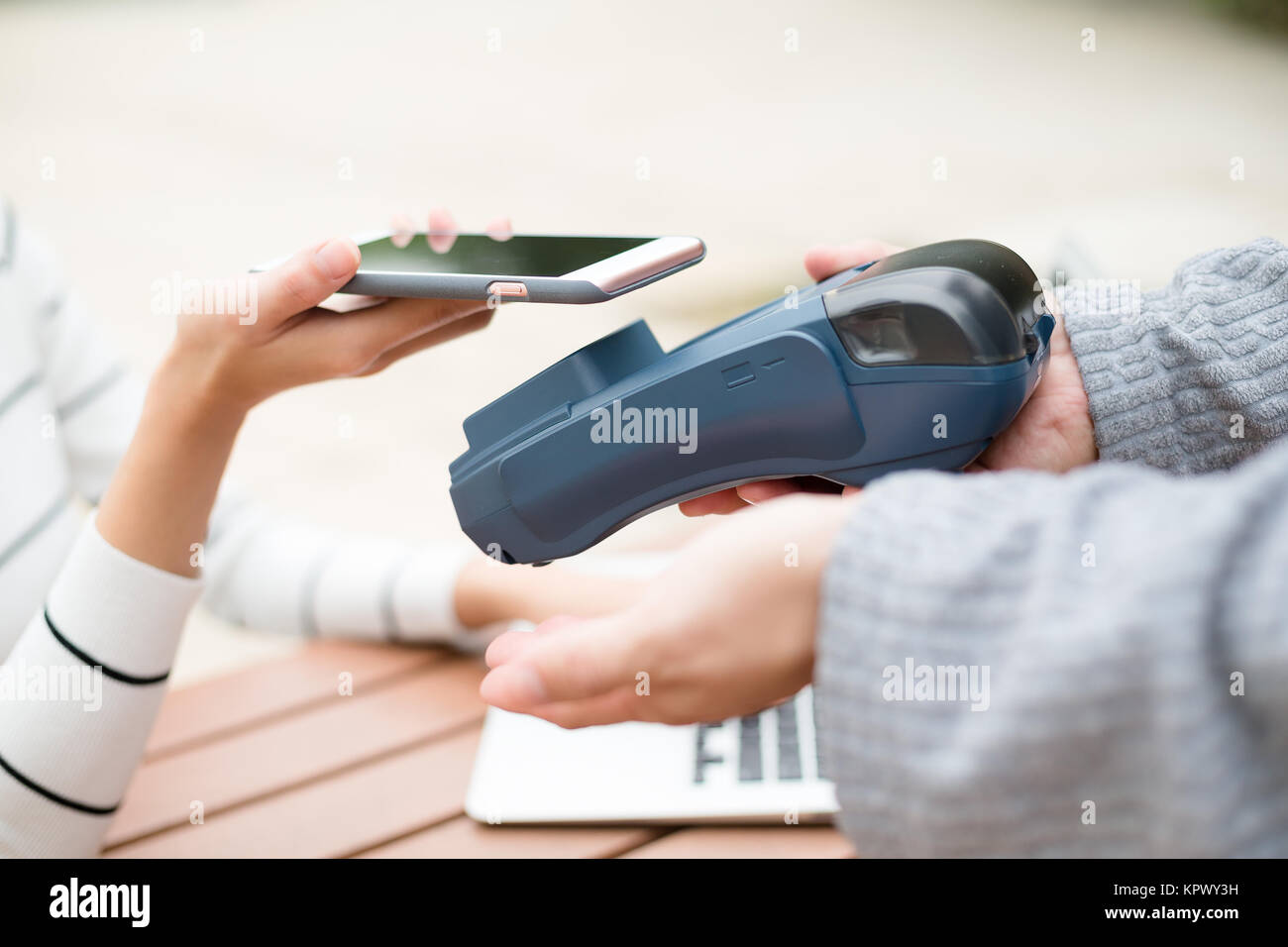 Woman using mobile phone to pay Stock Photo - Alamy