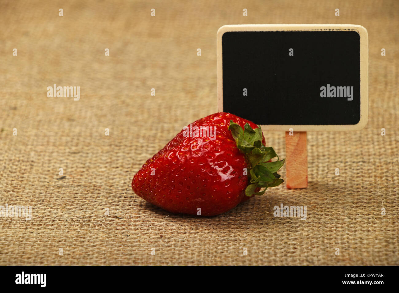One big strawberry with price sign on canvas Stock Photo - Alamy