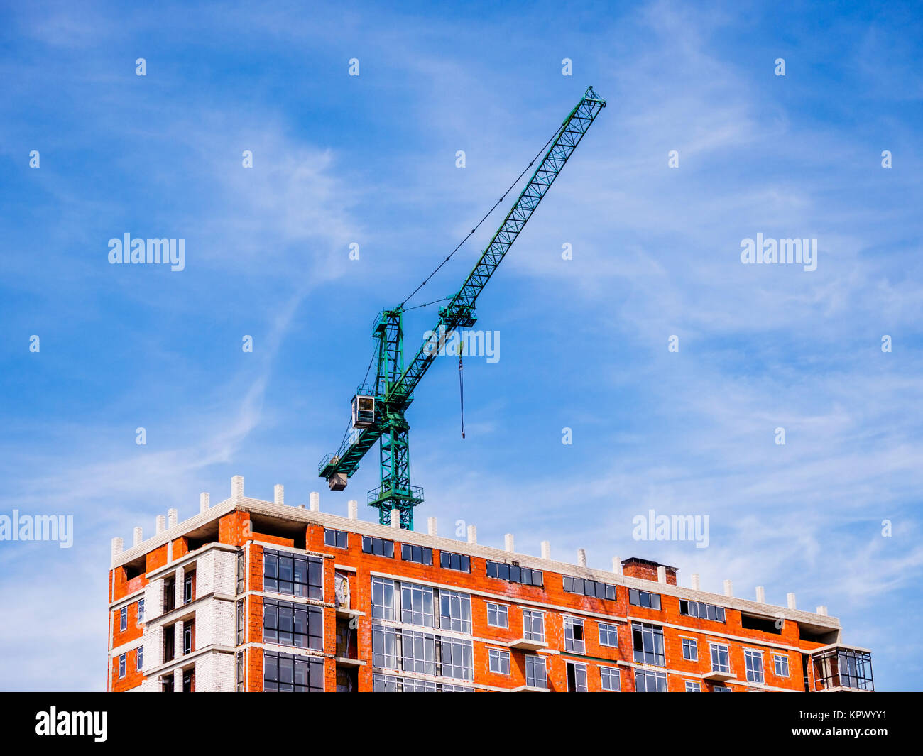Green construction crane with blue sky background Stock Photo - Alamy