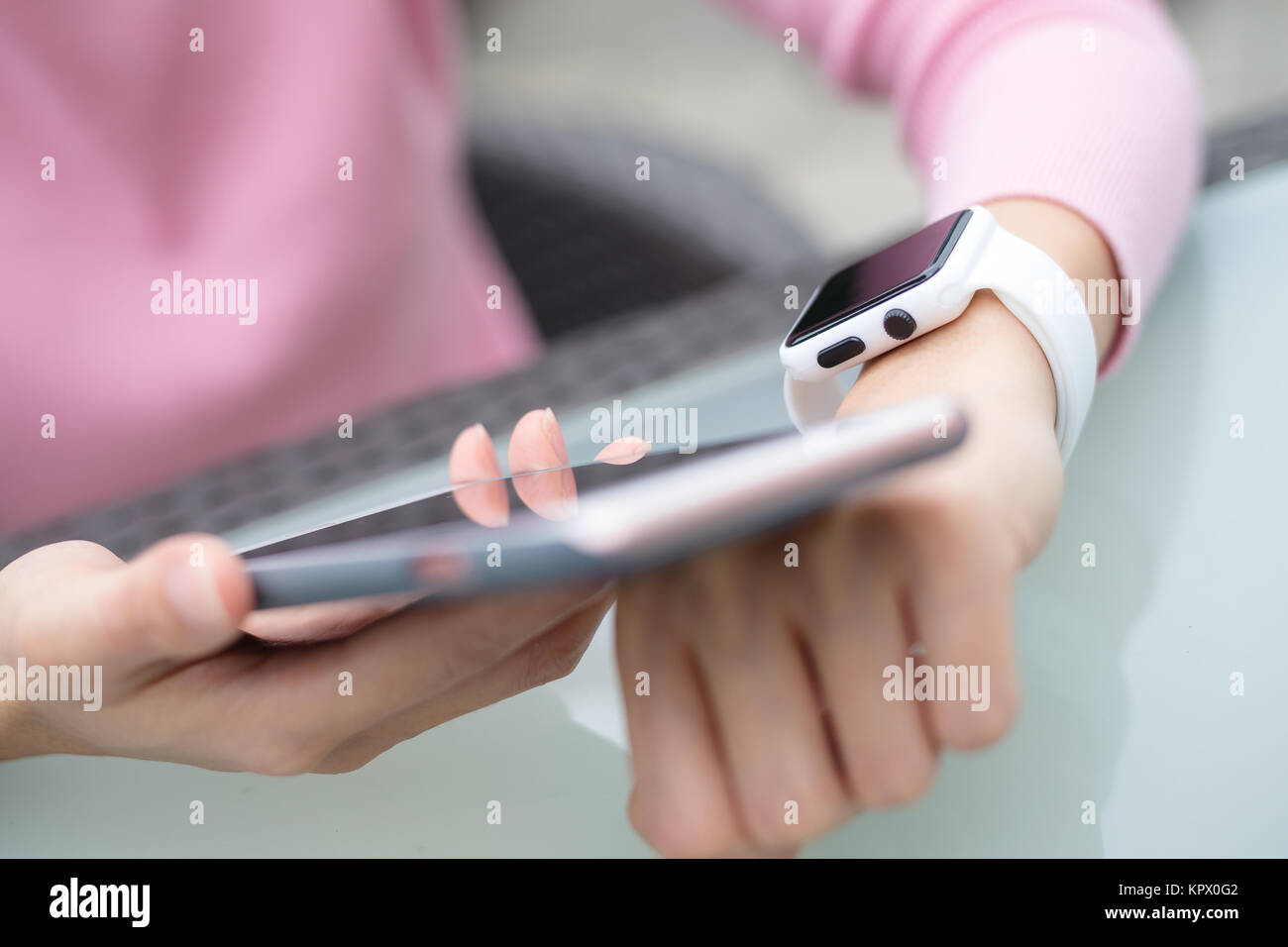 Woman using cellphone to connect with smart watch Stock Photo - Alamy