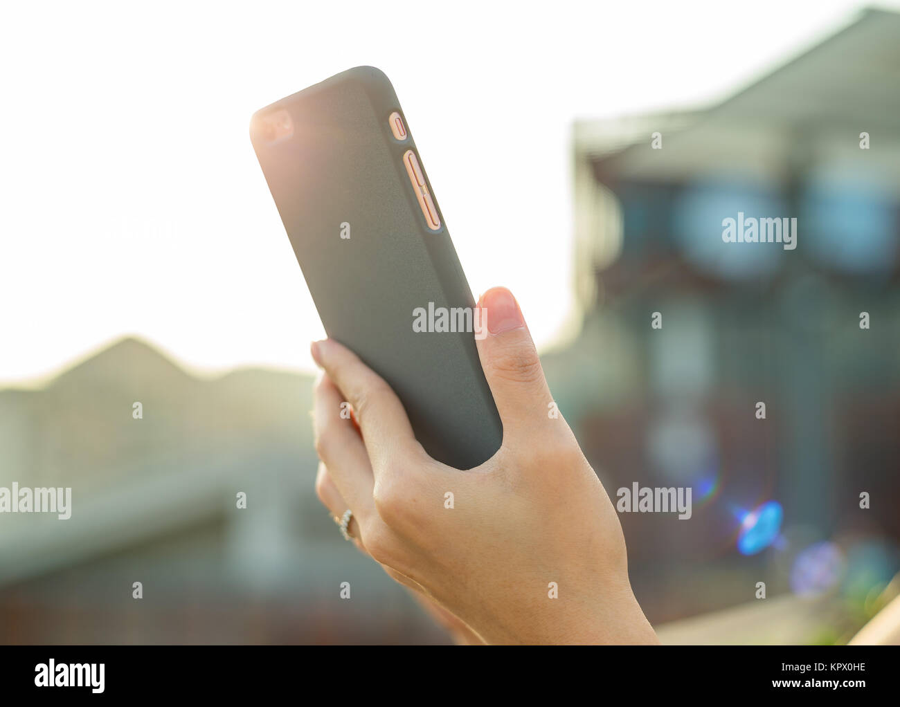 Woman using cellphone under sunlight Stock Photo - Alamy