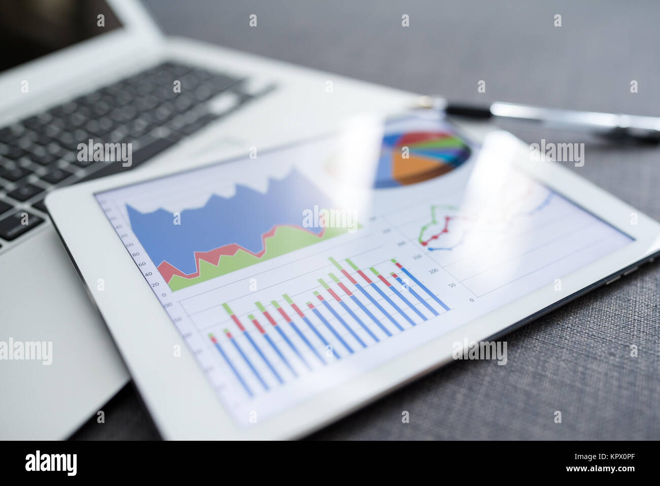 Tablet computer and financial charts Stock Photo - Alamy