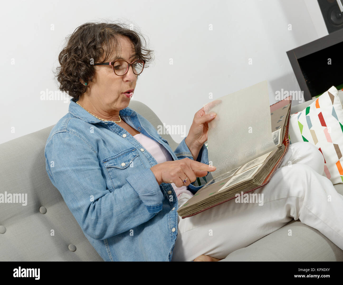 middle-aged woman looking at photo album Stock Photo - Alamy