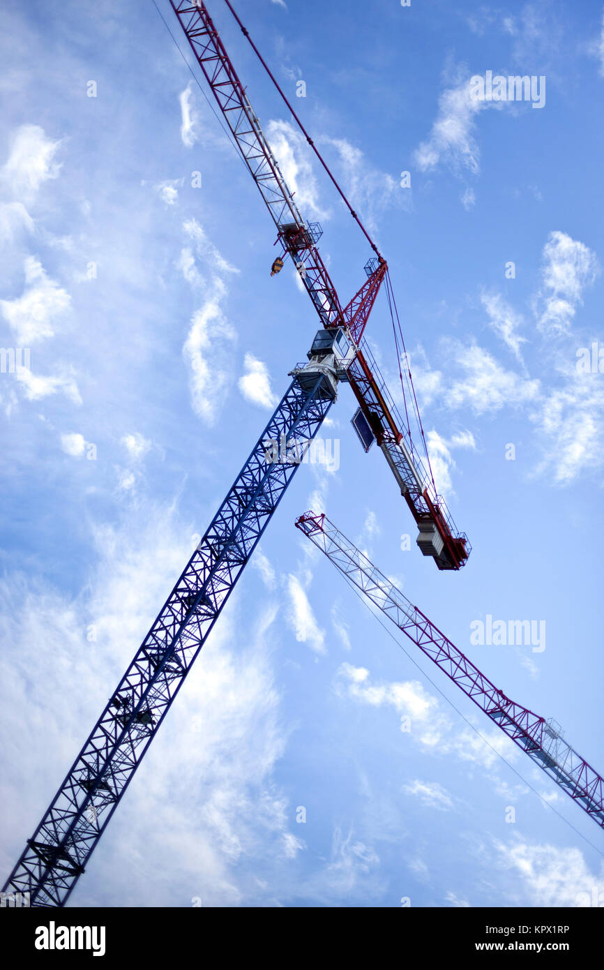 Cranes on a blue sky background Stock Photo - Alamy