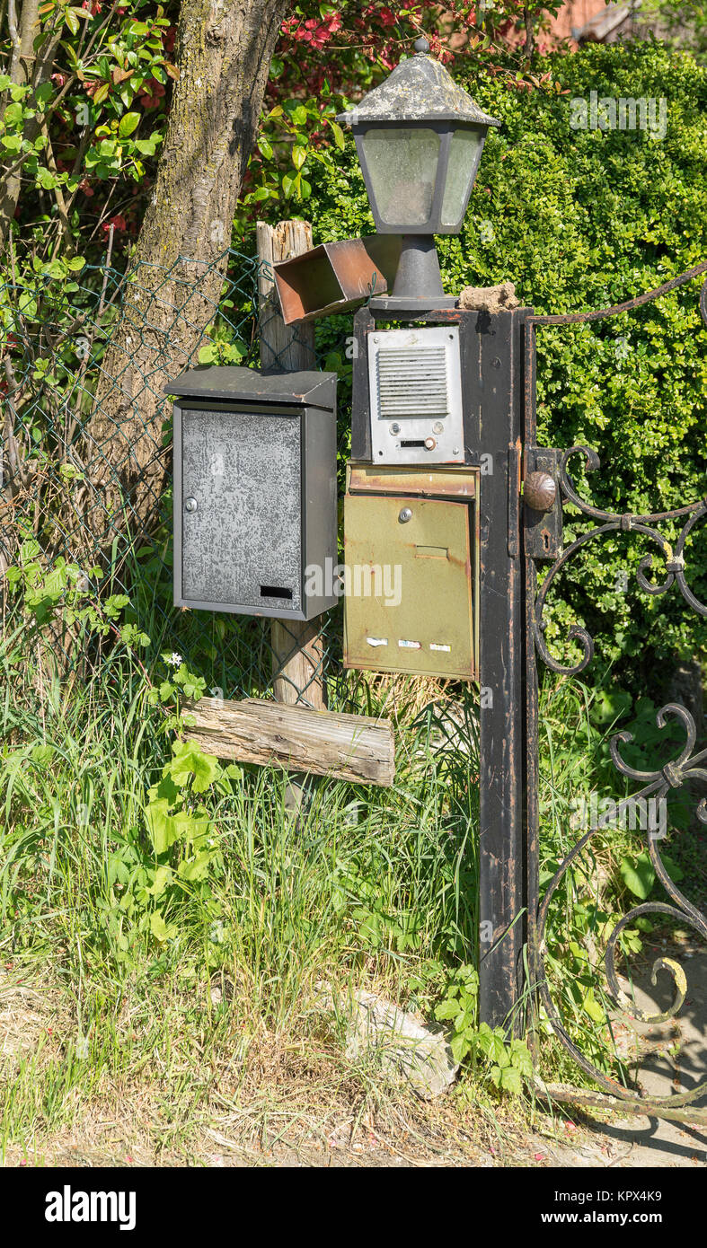 sunny illuminated scenery showing a garden gate with letter boxes ...