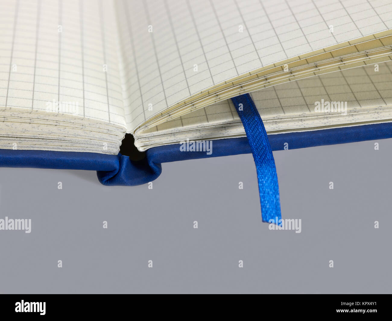 a open blue notebook with graph paper detail and bookmark in grey back ...