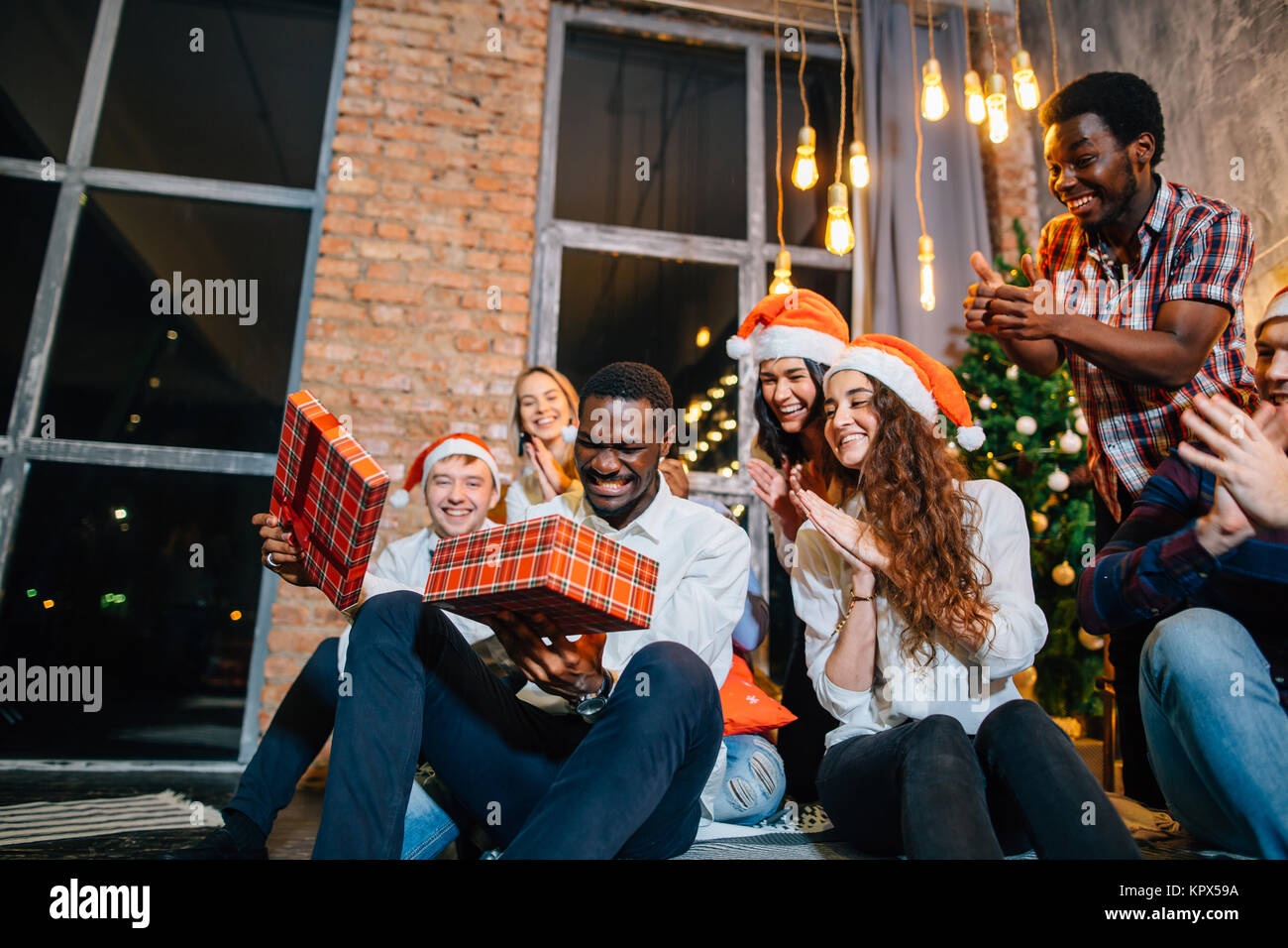 happy smiling friends opening magic Christmas gift Stock Photo - Alamy