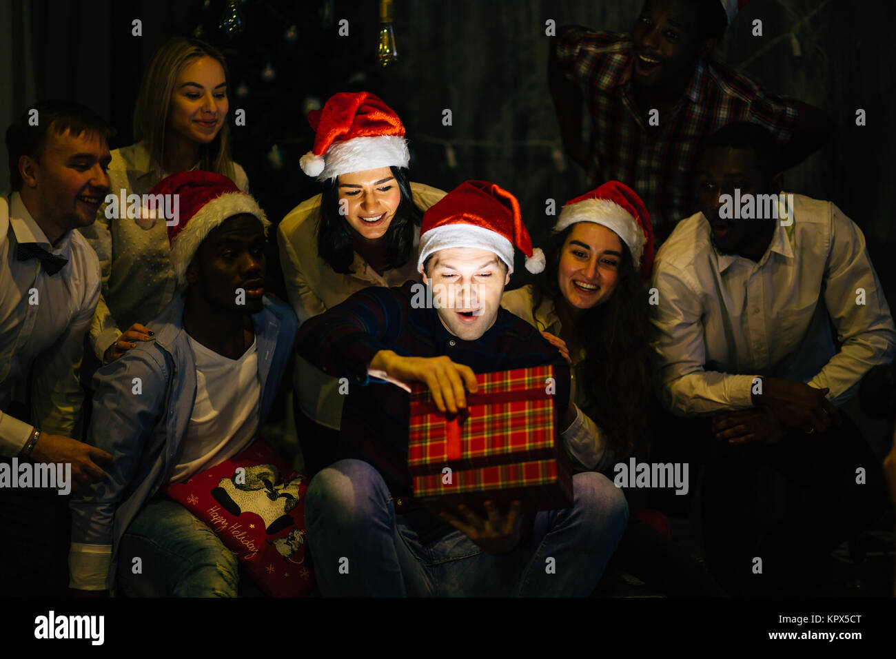 happy smiling friends opening magic Christmas gift Stock Photo - Alamy