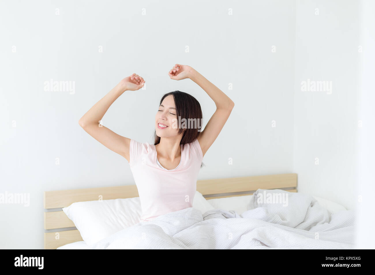 Woman waking up and yawning with a stretch Stock Photo - Alamy