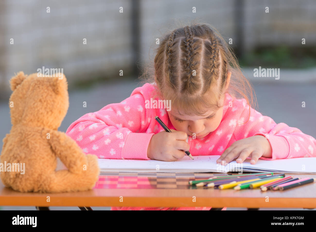 Offended girl draws a hunched figure in the yard Stock Photo - Alamy