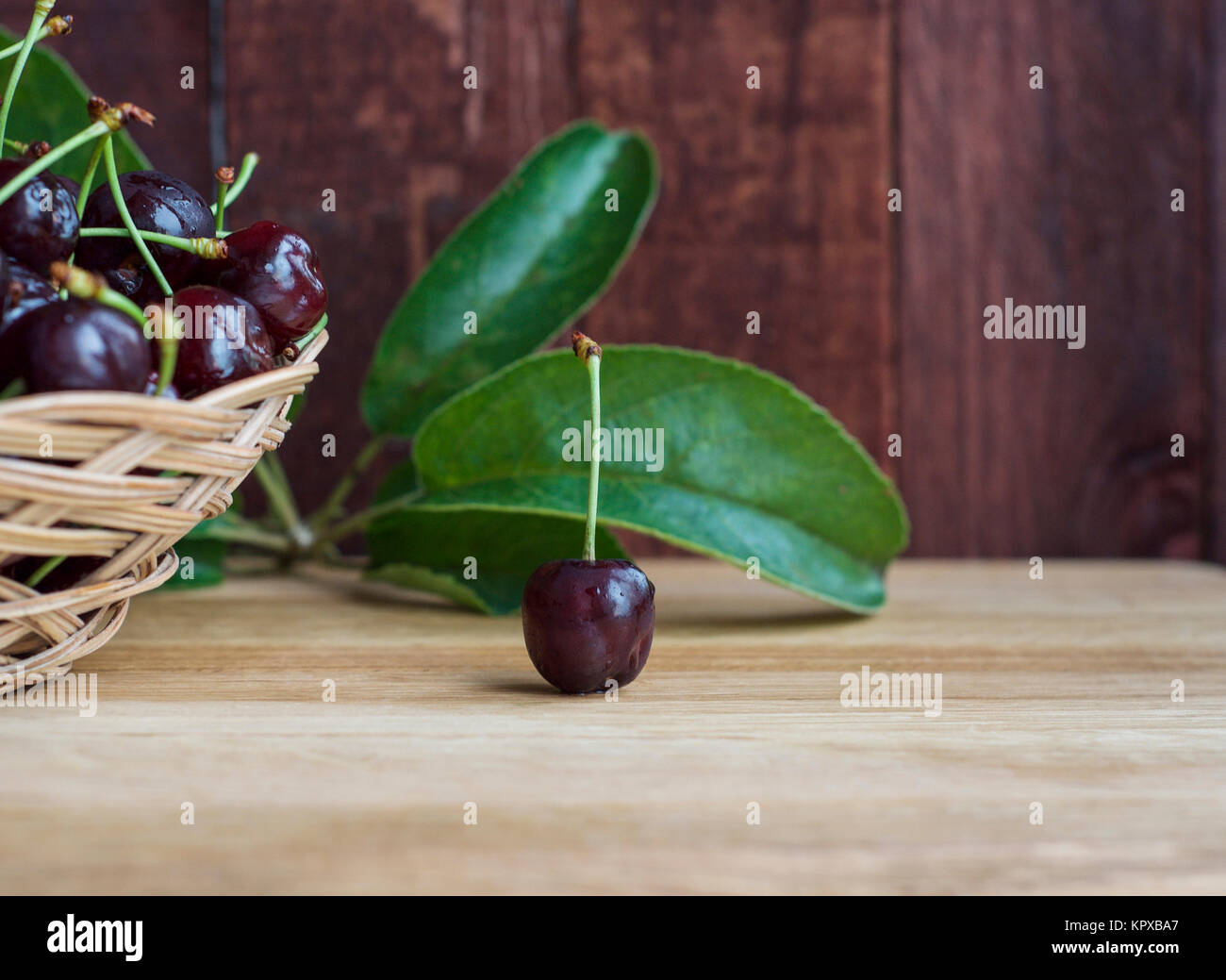 One cherry in the middle of the table Stock Photo - Alamy