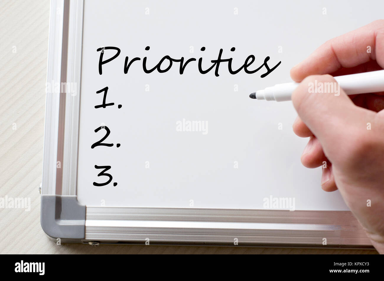 Priorities written on whiteboard Stock Photo - Alamy
