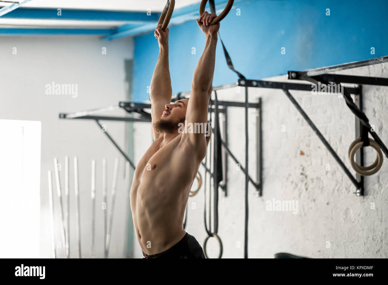 Muscle-up exercise athletic man doing intense workout at gym on ...