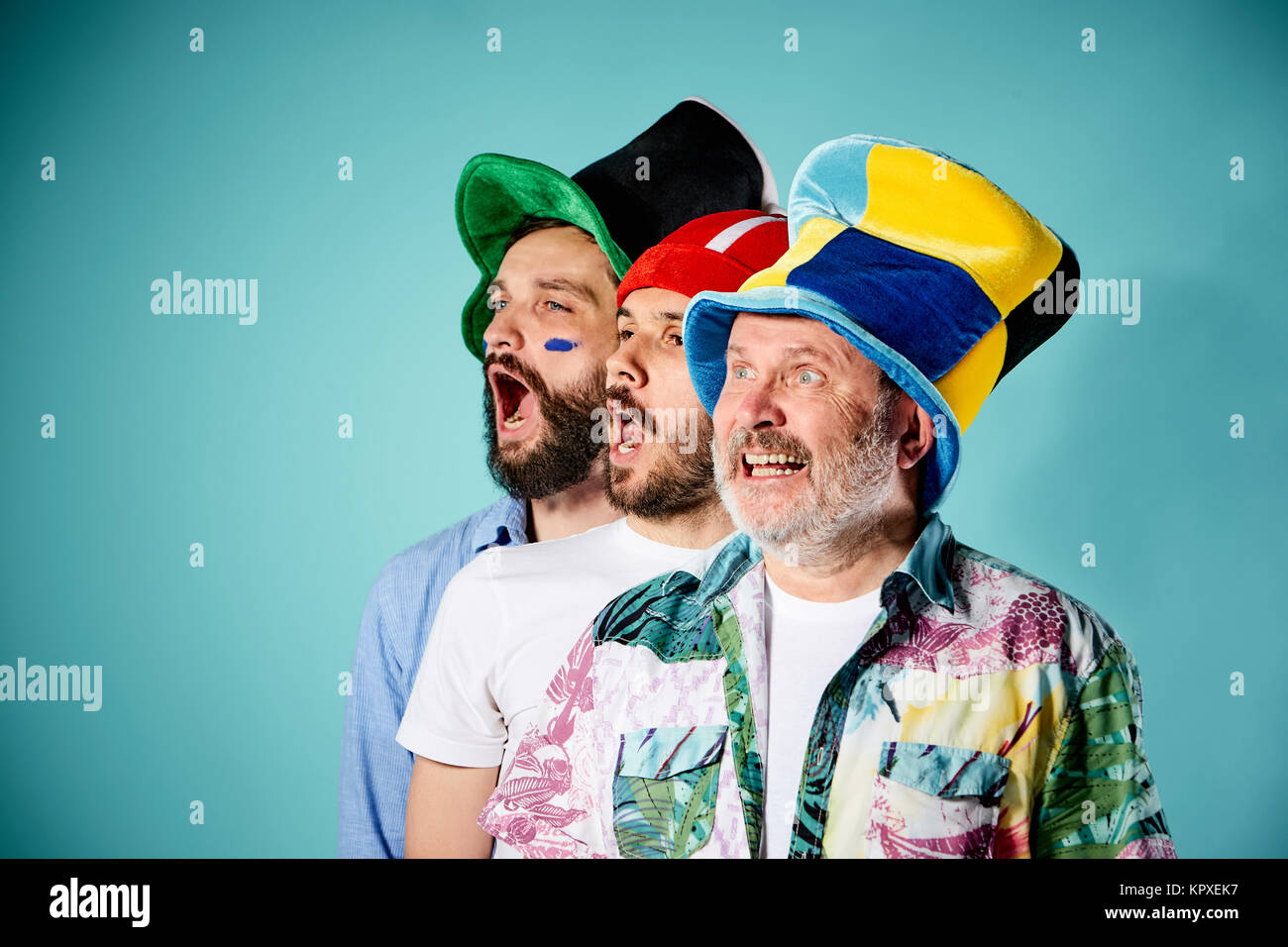 The three football fans singing the national anthem over blue Stock ...