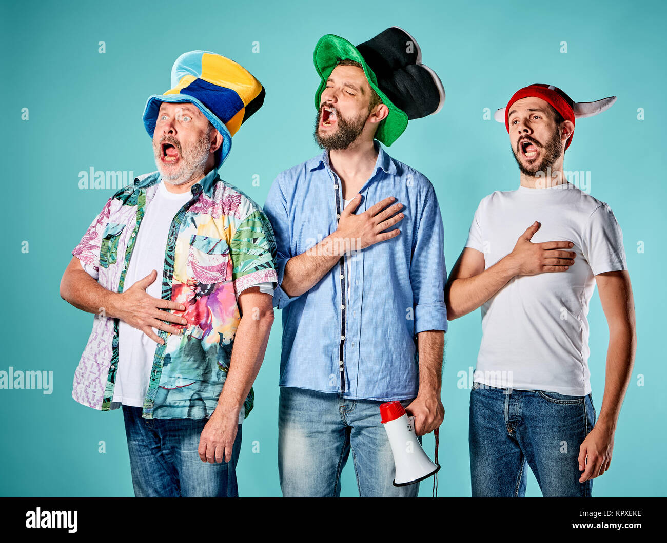 The three football fans singing the national anthem over blue Stock ...
