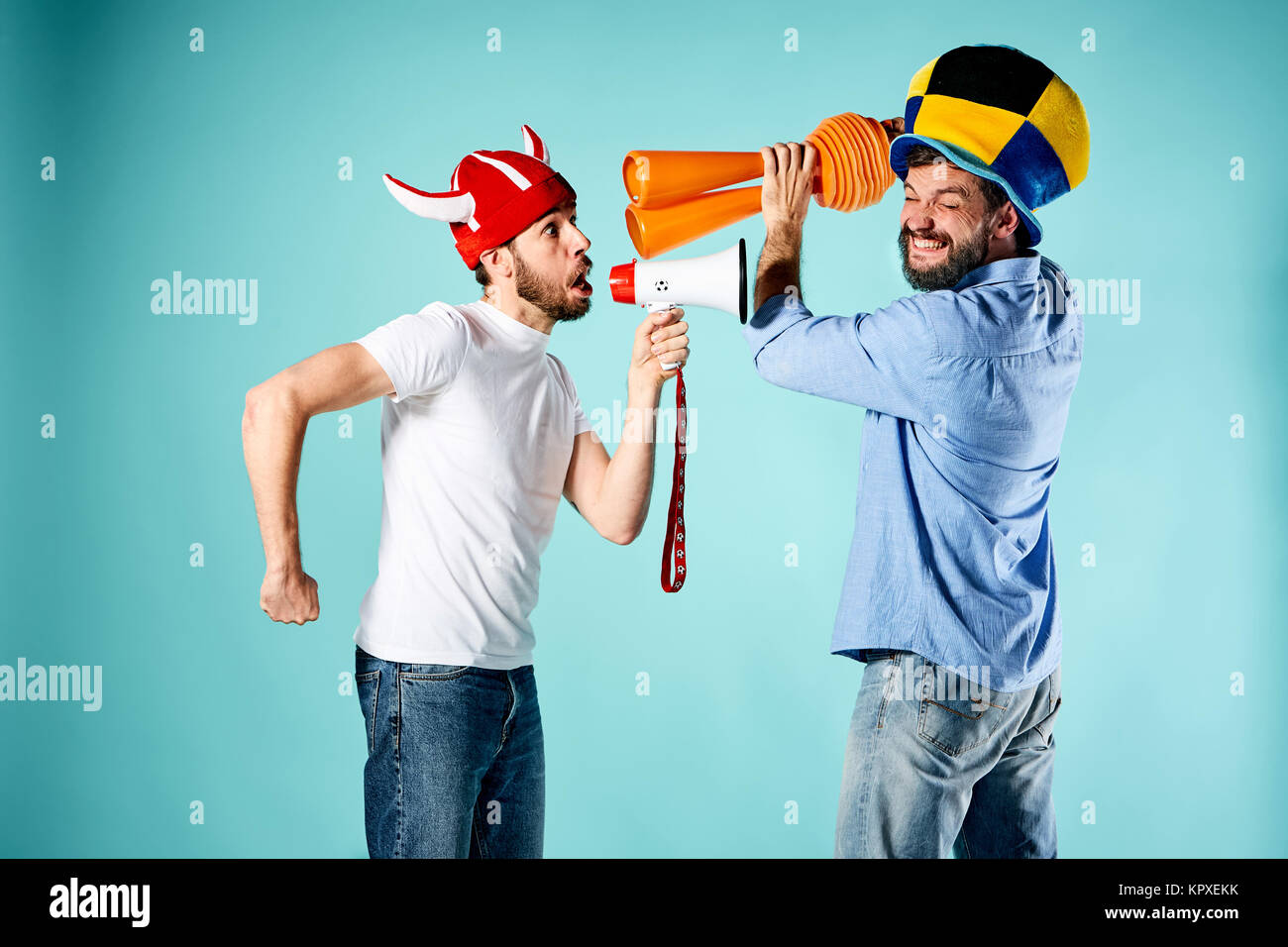 The two football fans with mouthpiece over blue Stock Photo - Alamy
