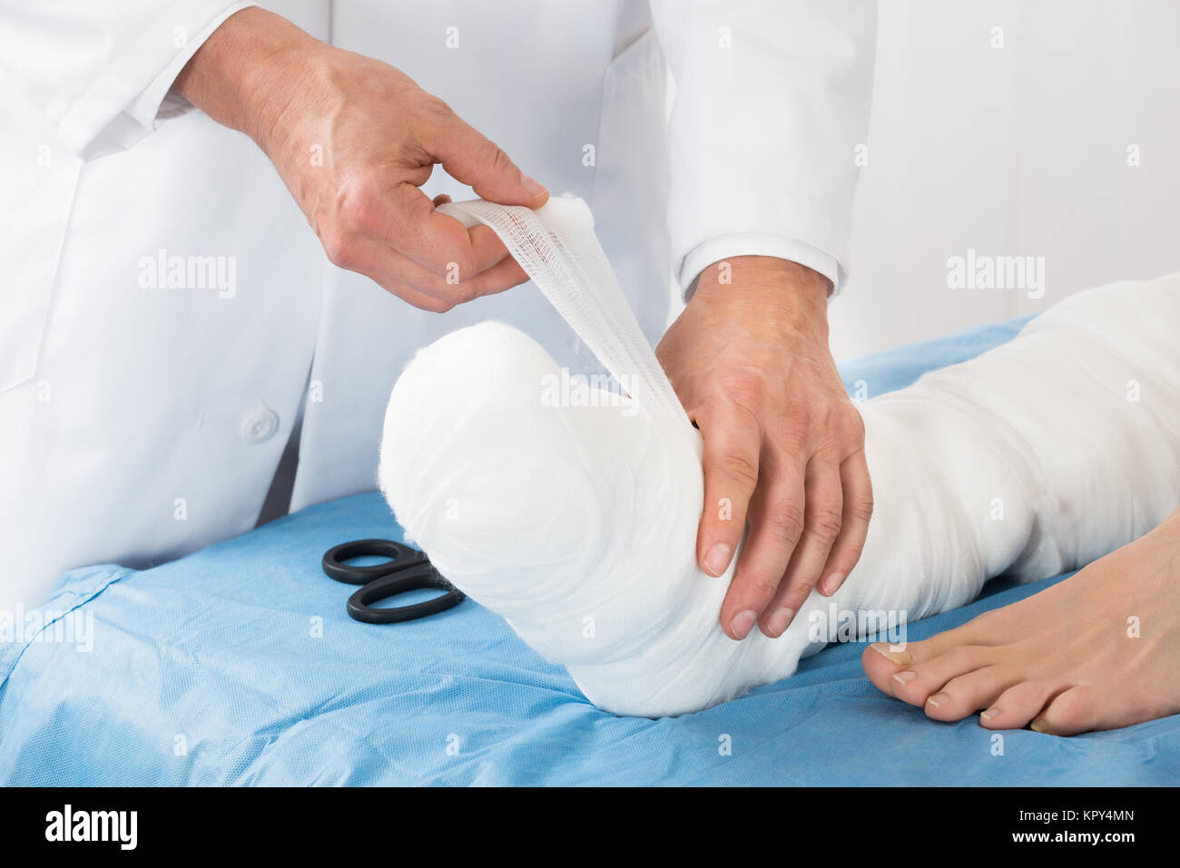 Doctor Tying Bandage On Patient Leg Stock Photo - Alamy