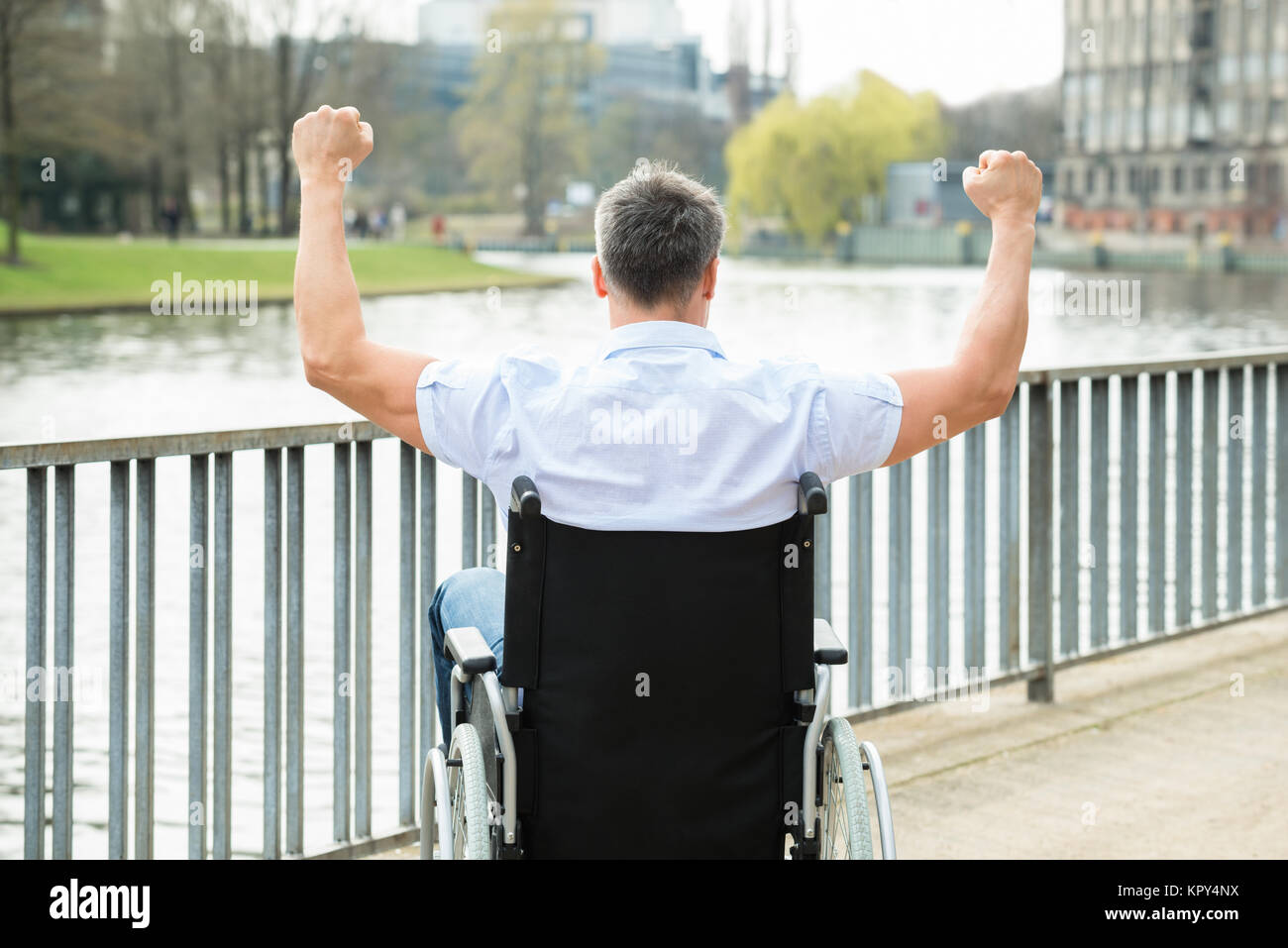 Disabled Man On Wheelchair With Hand Raised Stock Photo - Alamy