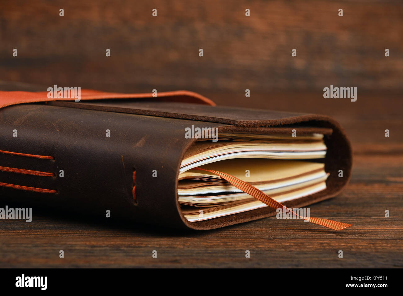 Notebook in leather cover on wooden table Stock Photo - Alamy