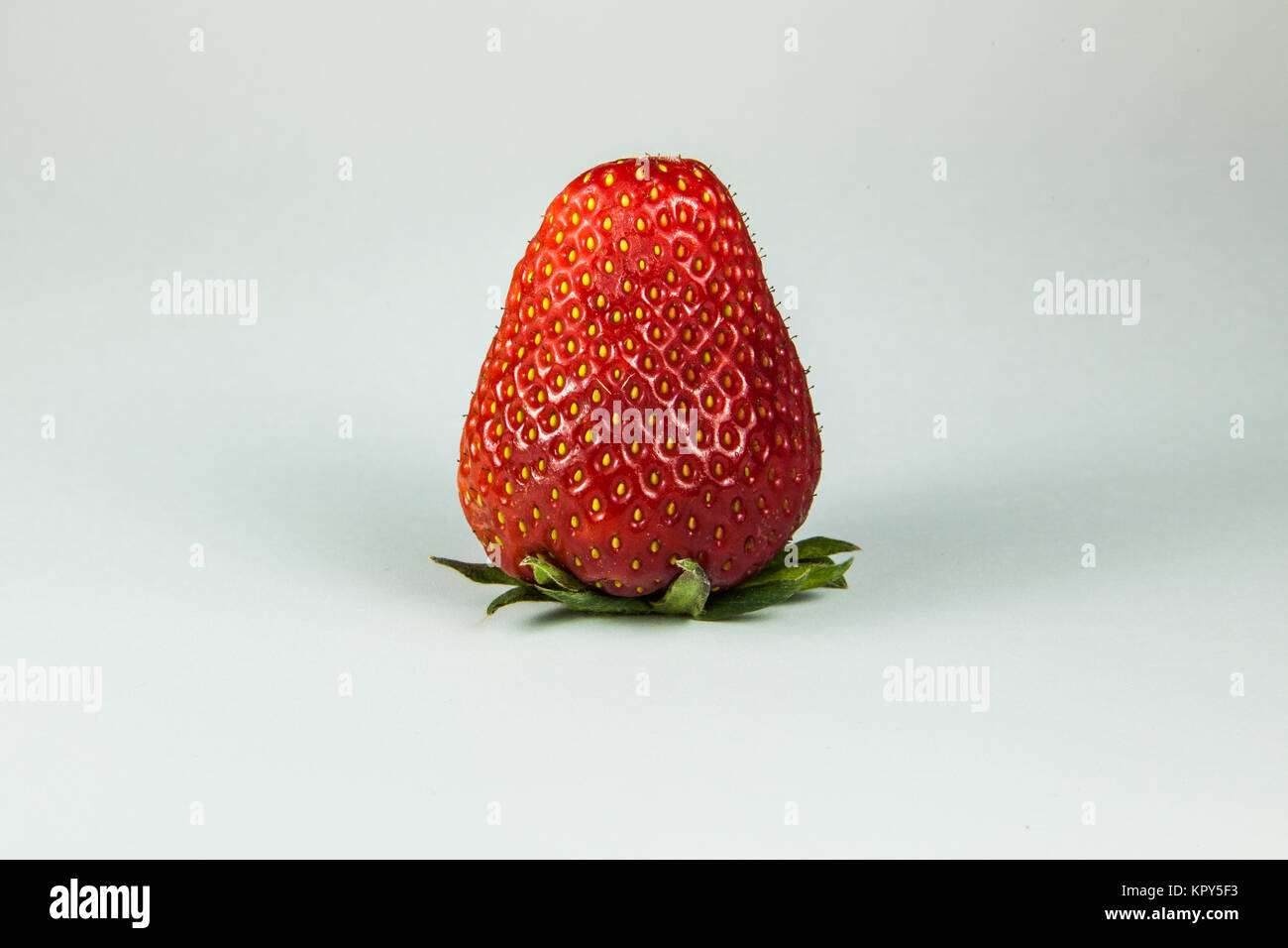 Upside down strawberry ona white table Stock Photo - Alamy