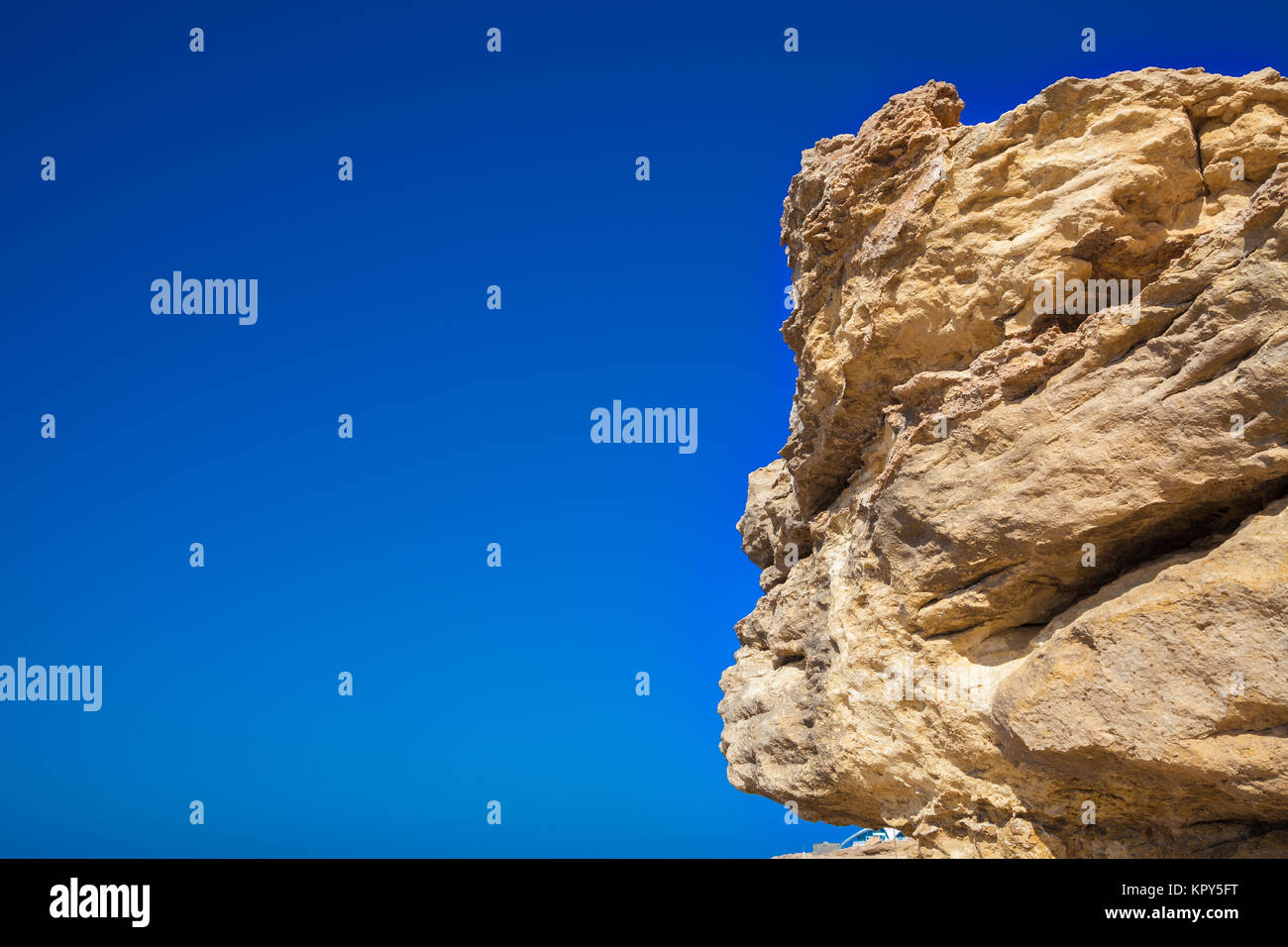A sea rock over a clear blue sky Stock Photo - Alamy