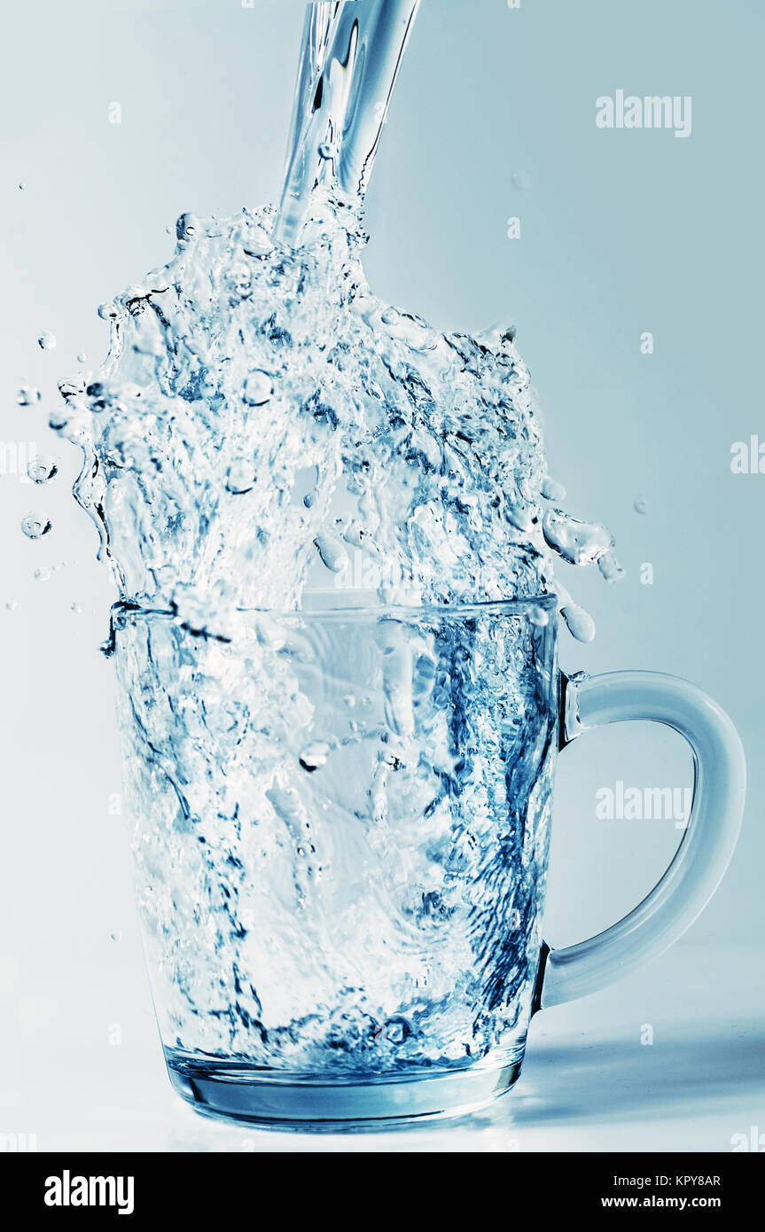 Pouring water into a glass mug Stock Photo - Alamy