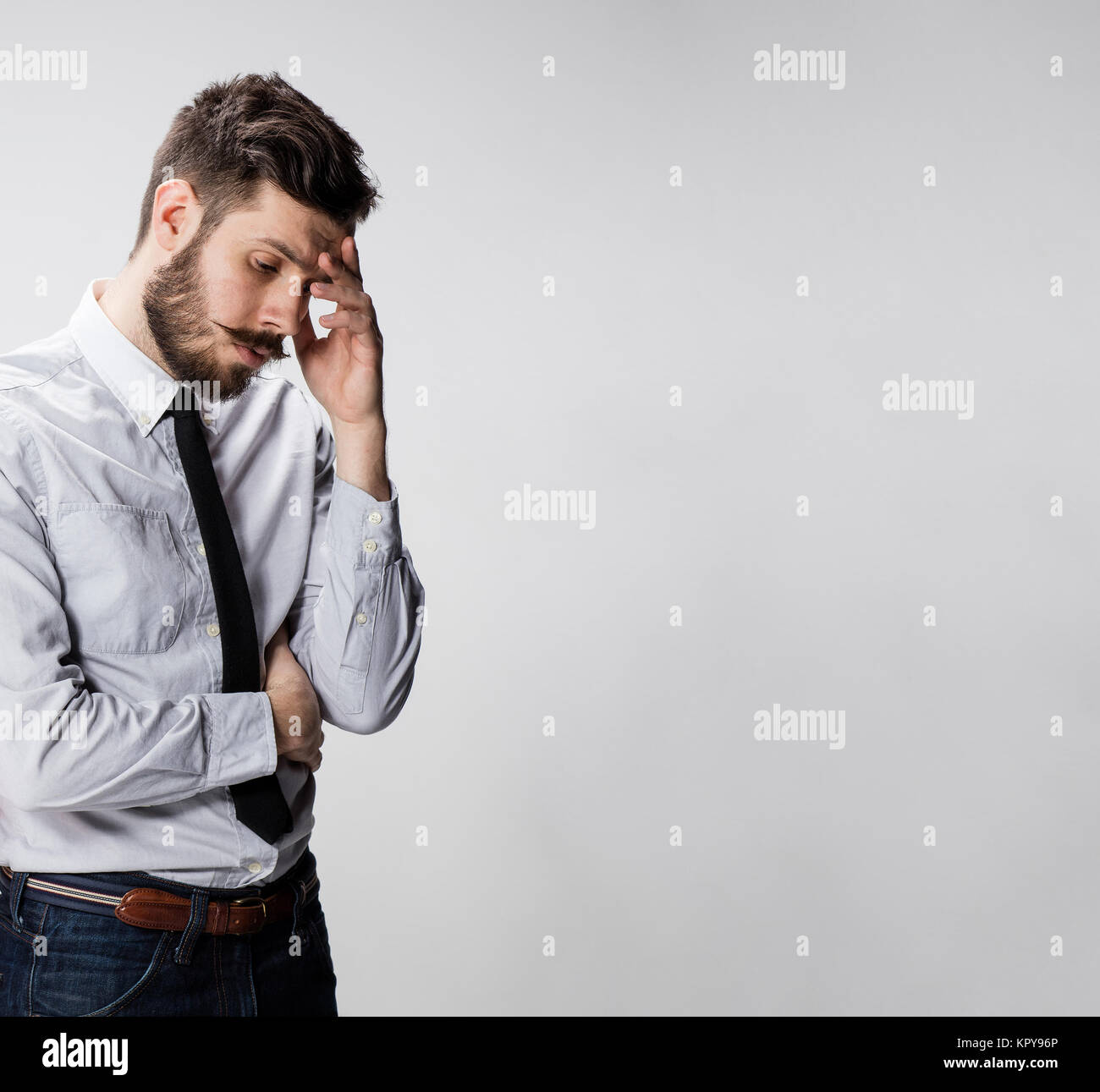 The young handsome man doubting over gray Stock Photo - Alamy