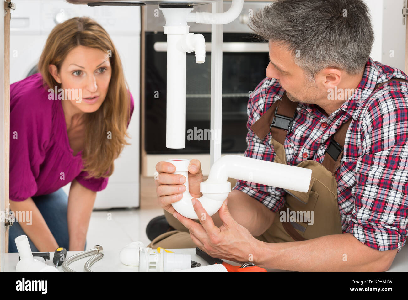 Woman fixing plumbing under sink hi-res stock photography and images ...