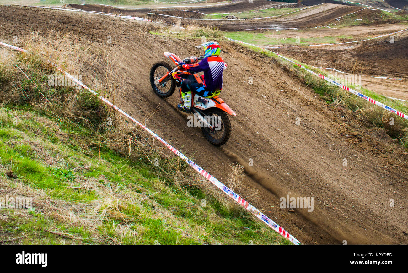 A rider on a motorcycle participates in a motocross race, enters a hill ...