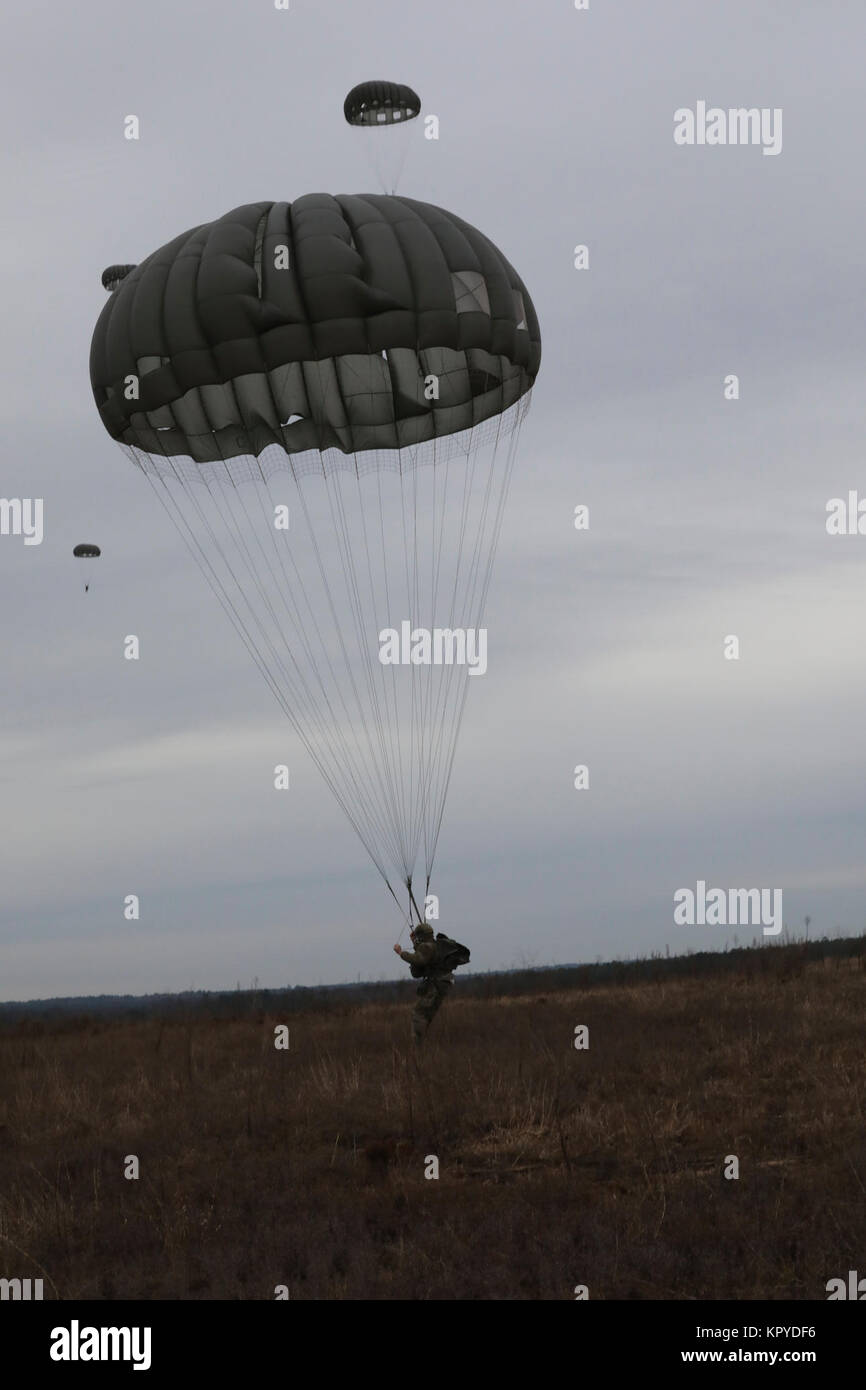 U.S. Army paratrooper prepares to land after completing their jump from ...