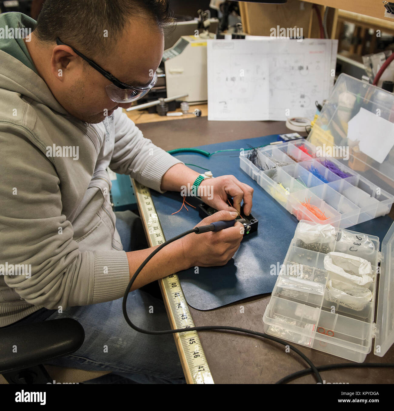 Electronic Technician Loi Vu solders wire to one of two connectors in a ...