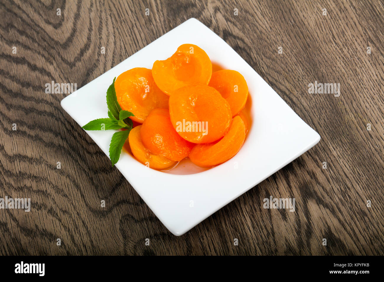 Canned apricots with mint leaves Stock Photo - Alamy