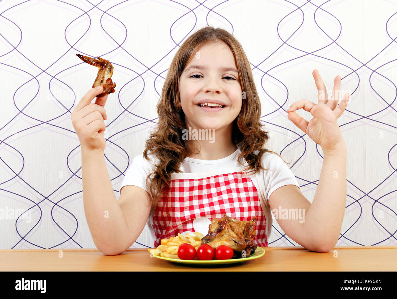 happy little girl with roasted chicken wings and ok hand sign Stock ...